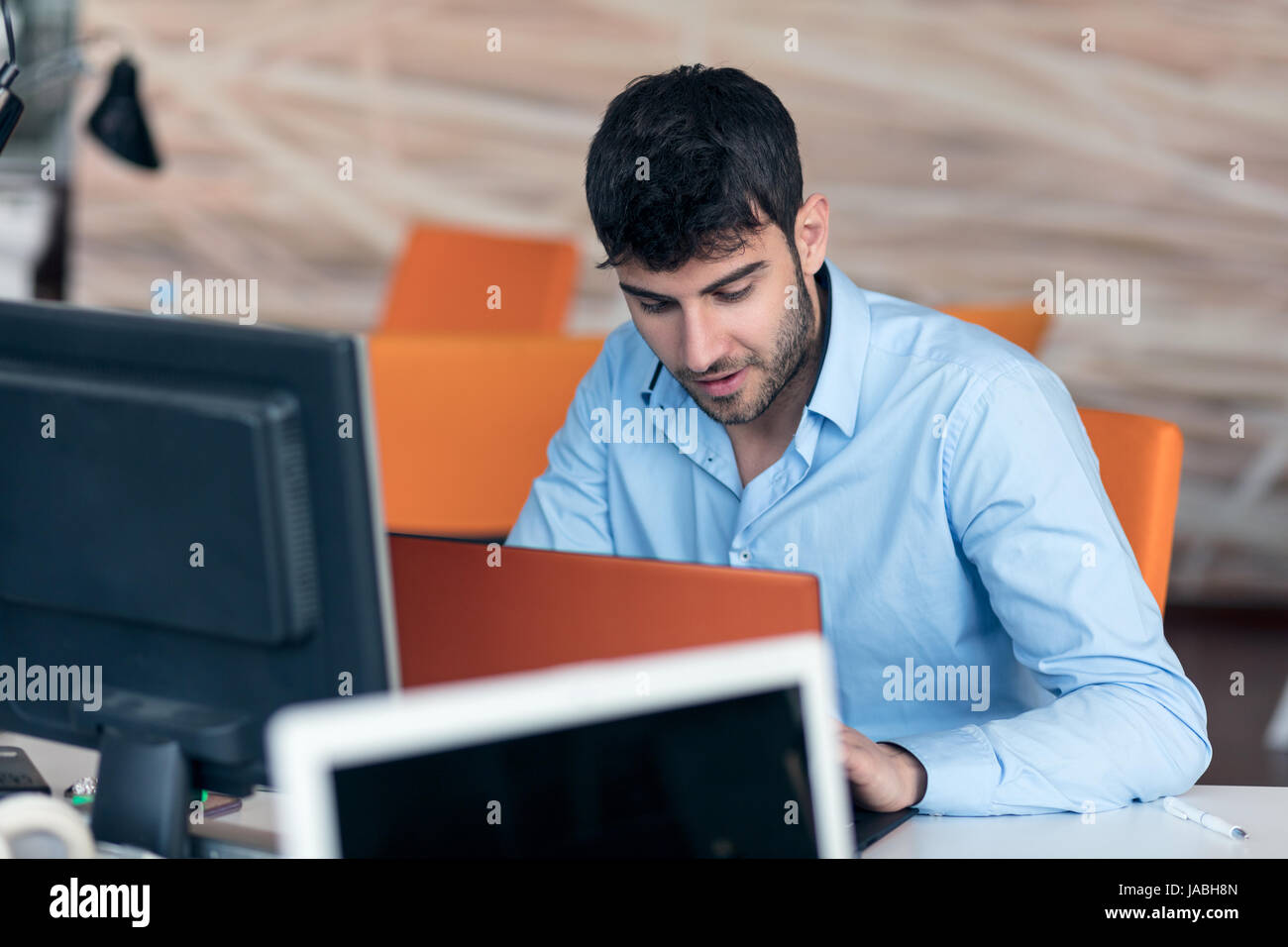 happy young business man working on desktop computer at his desk in ...