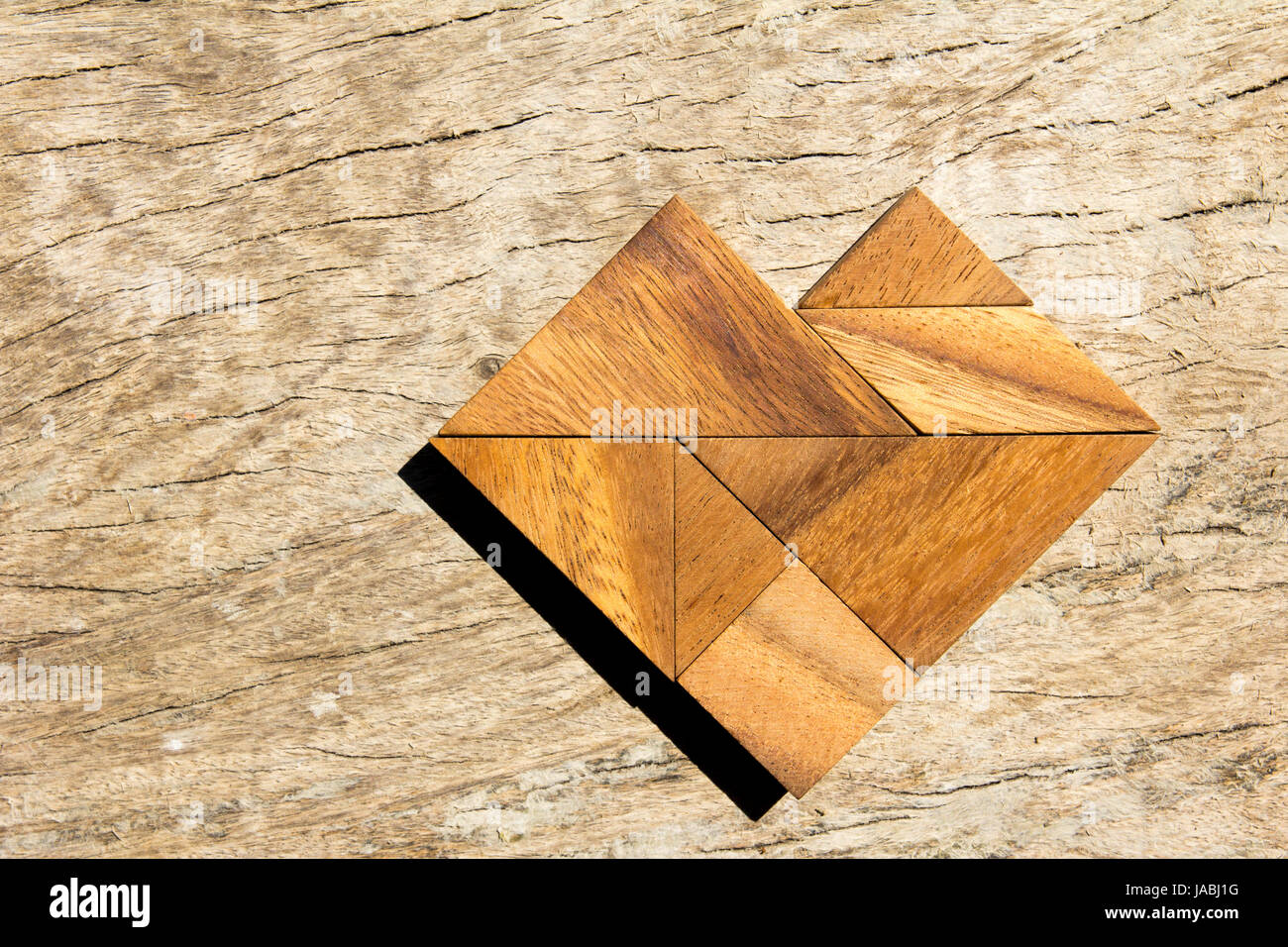 Tangram puzzle in heart shape on wooden background Stock Photo - Alamy