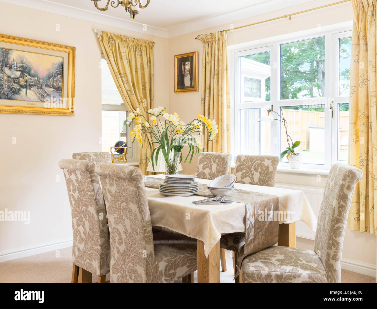 A dining table dressed with table cloth with silverware & crockery ...