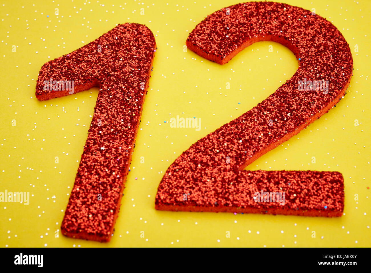 Number twelve red color over a yellow background. Anniversary ...