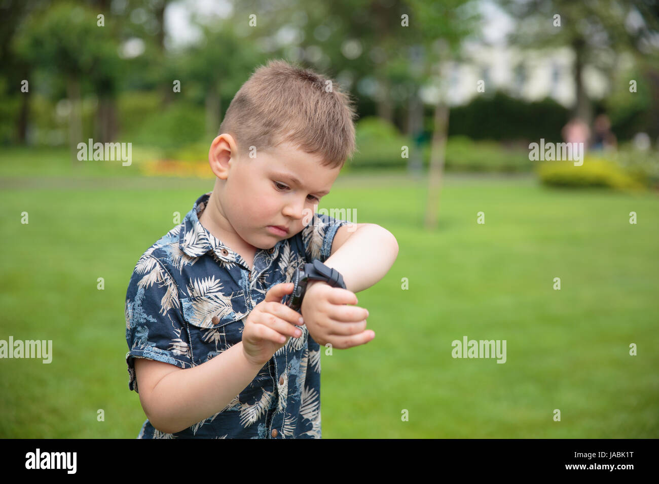 little boy considering watch on his hand Stock Photo - Alamy