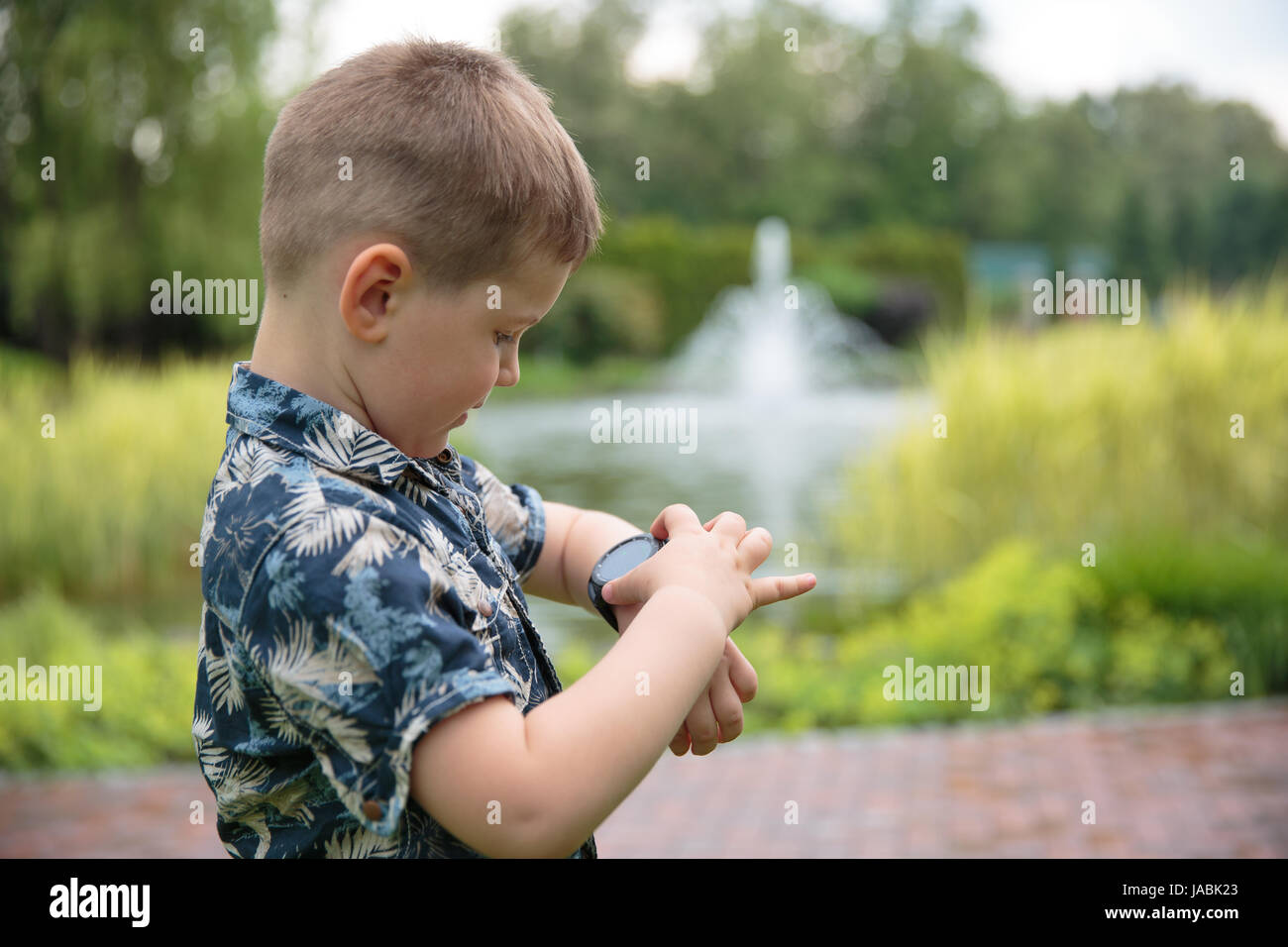 little boy considering watch on his hand Stock Photo - Alamy