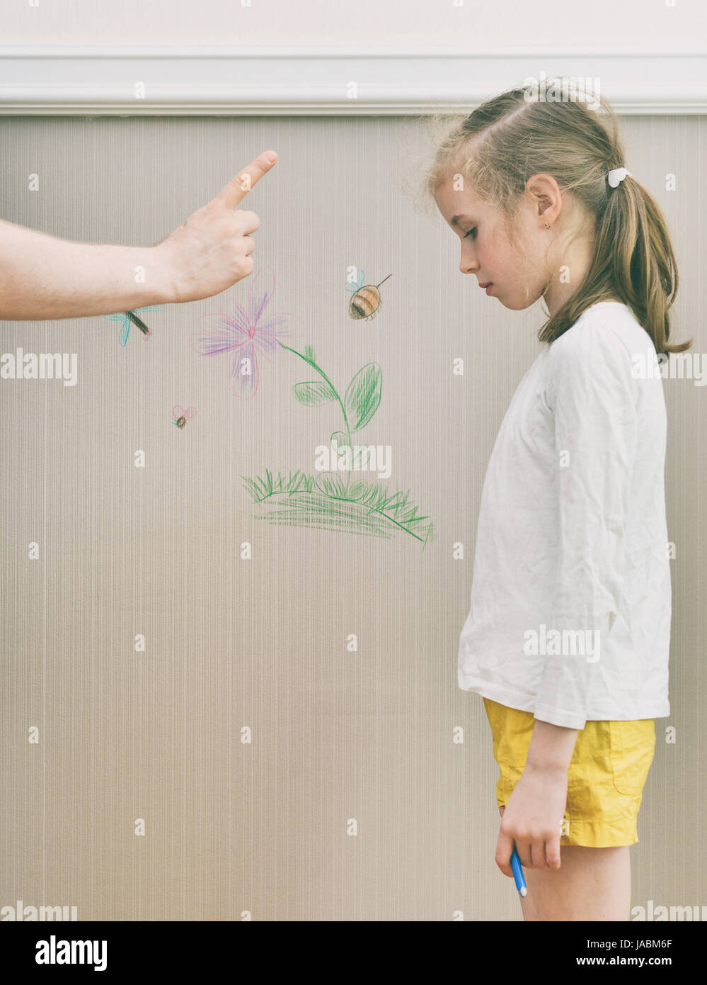 Little girl spoiled the wallpaper and her dad is angry Stock Photo - Alamy