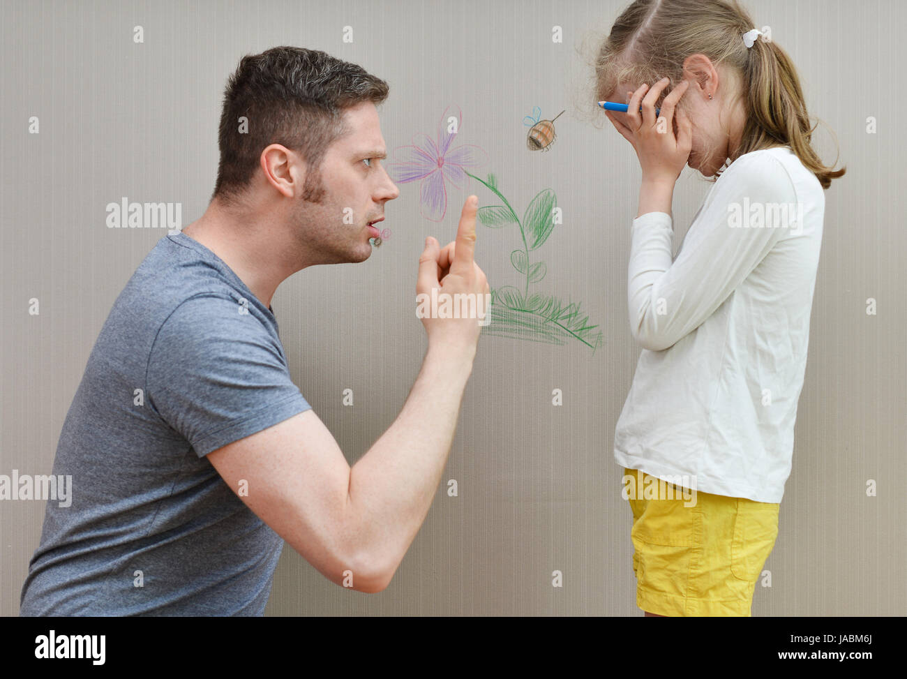 Little girl spoiled the wallpaper and her dad is angry Stock Photo - Alamy