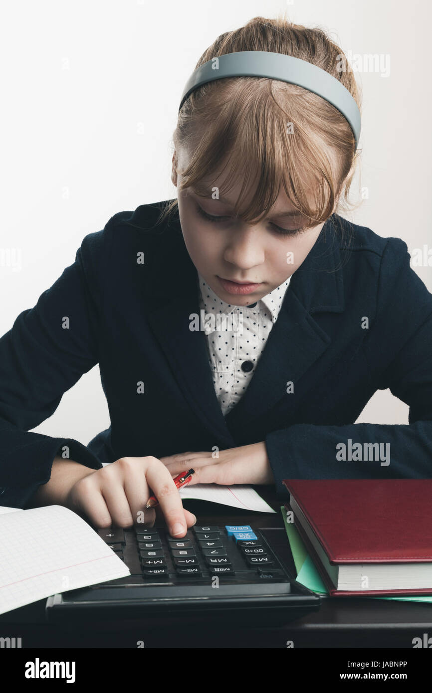 School girl using calculator, closeup portrait over white wall ...