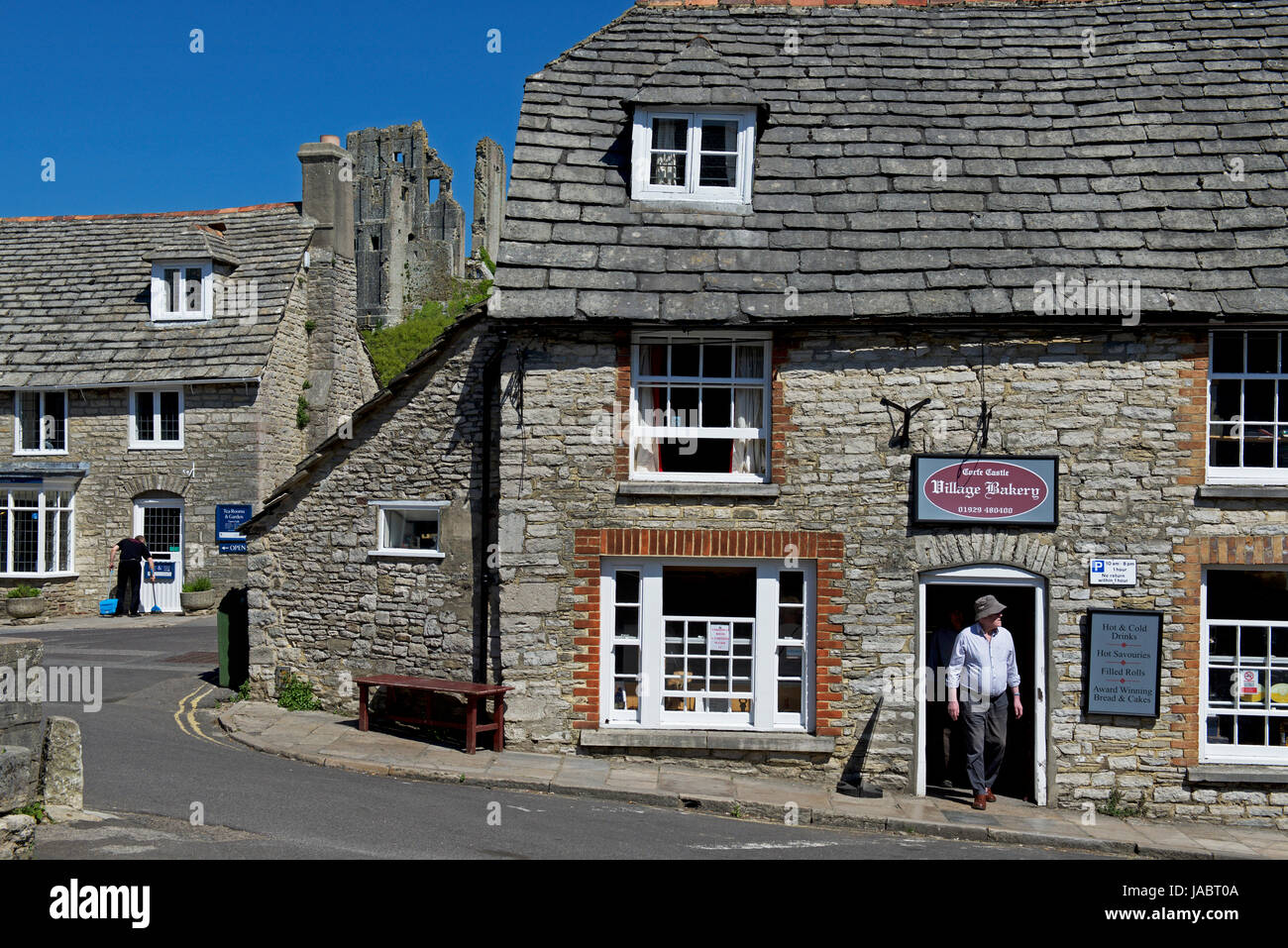 Man walking out of bakery shop in the village of Corfe Castle, Dorset ...