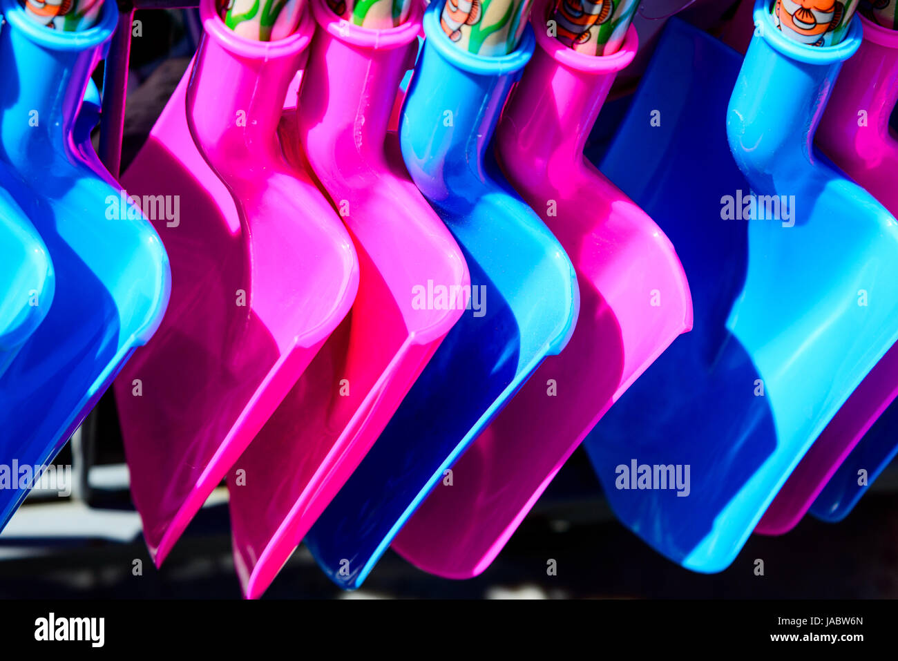 Selection of colourful plastic spades outside shop front. Tenby ...