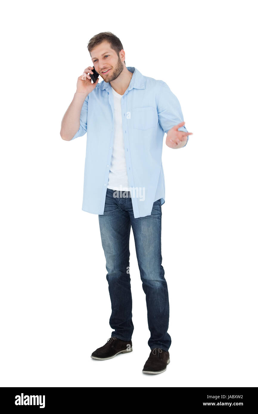 Relaxed male model posing while making a call on white background Stock ...