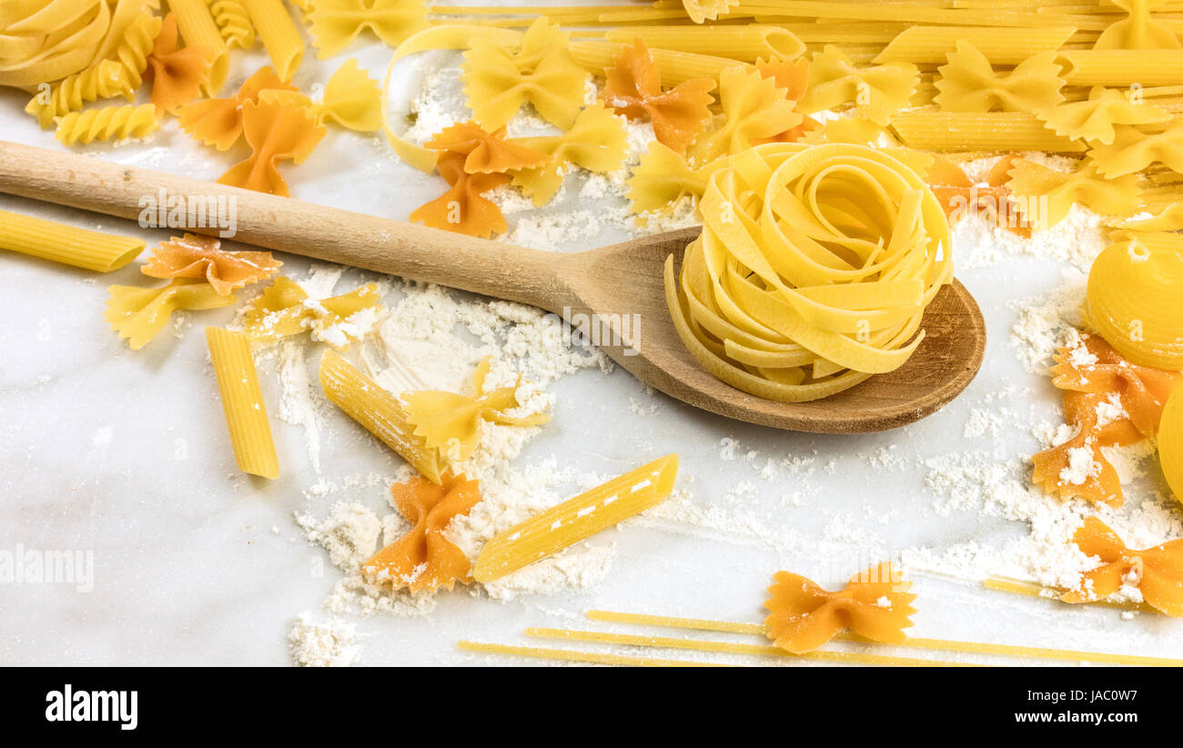 A closeup of various types of pasta, including pappardelle, farfalle ...