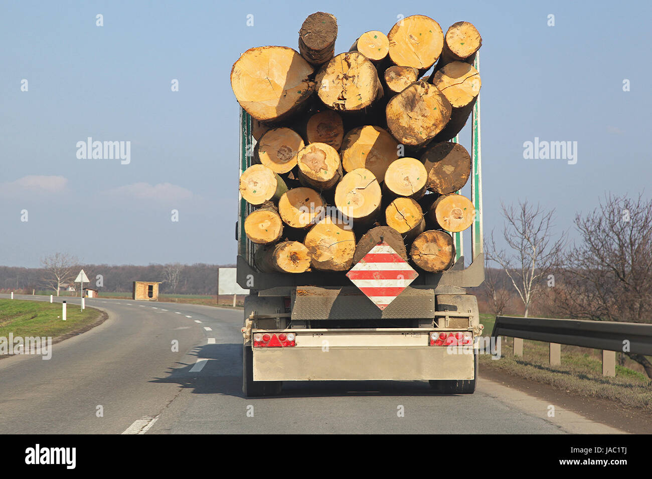 Timber lorry carry wooden logs at road Stock Photo - Alamy