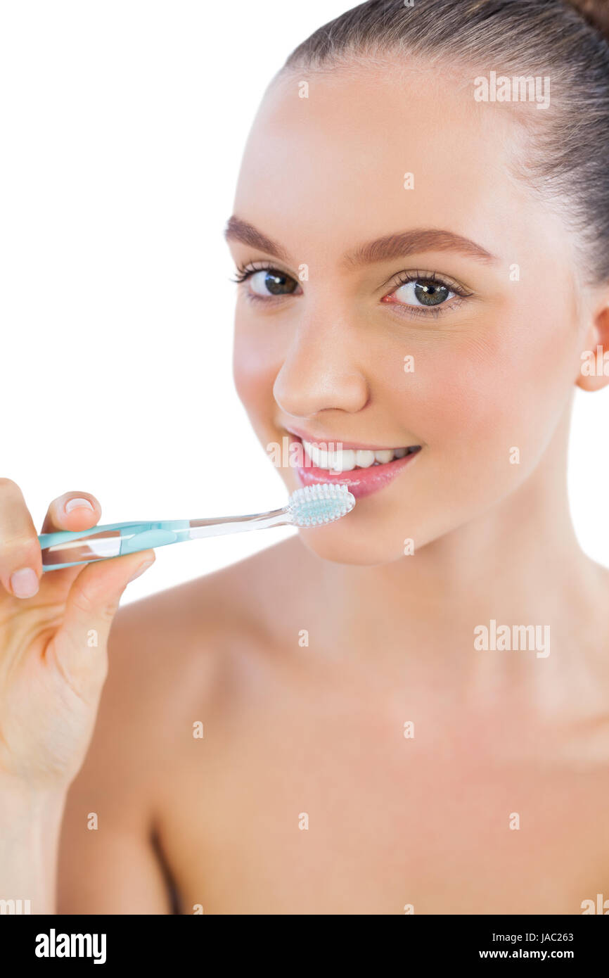 Young model using toothbrush and looking at camera Stock Photo - Alamy