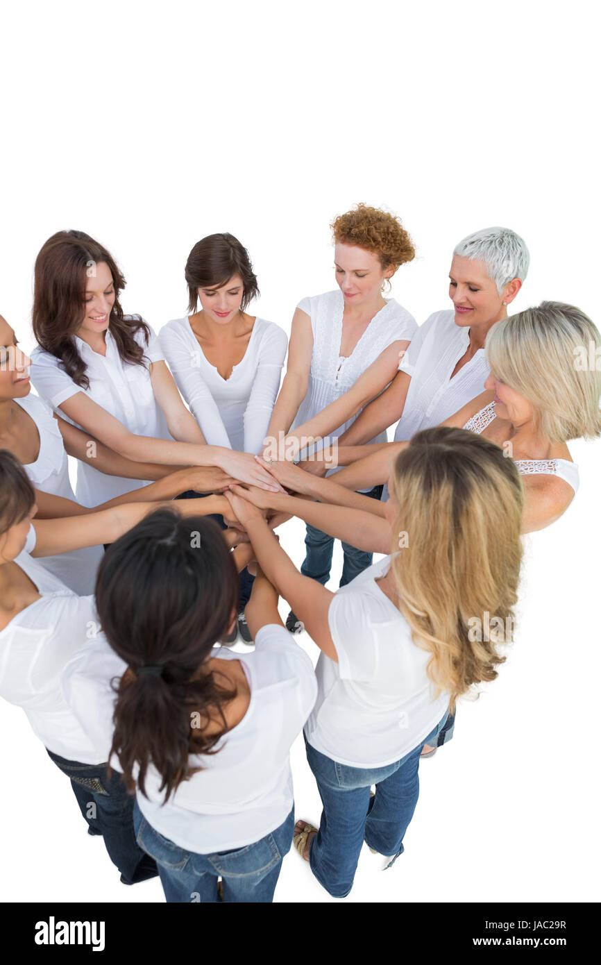 Happy female models joining hands in a circle on white background Stock ...