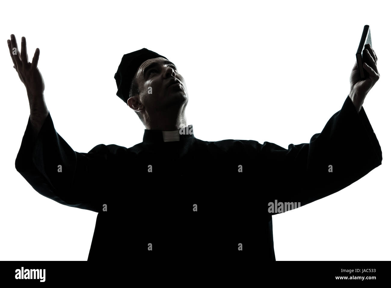 one caucasian man priest praying silhouette in studio isolated on white ...