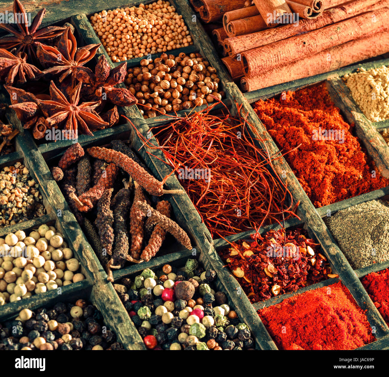 Variety of spices in an old printers tray with mixed peppercorns, red ...