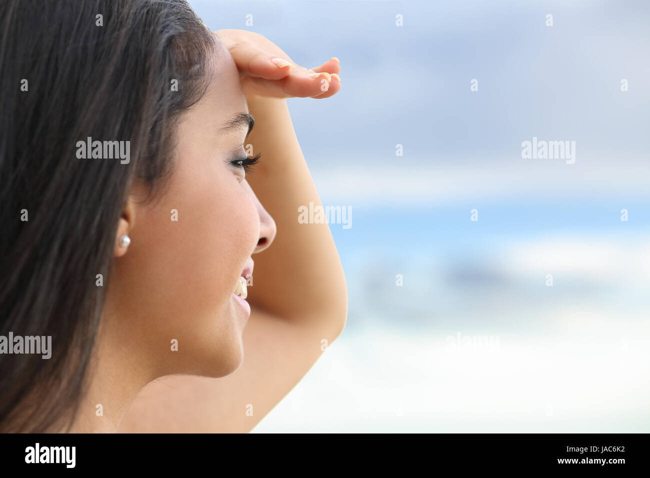 Close up of a beautiful woman looking at the horizon with a hand in ...