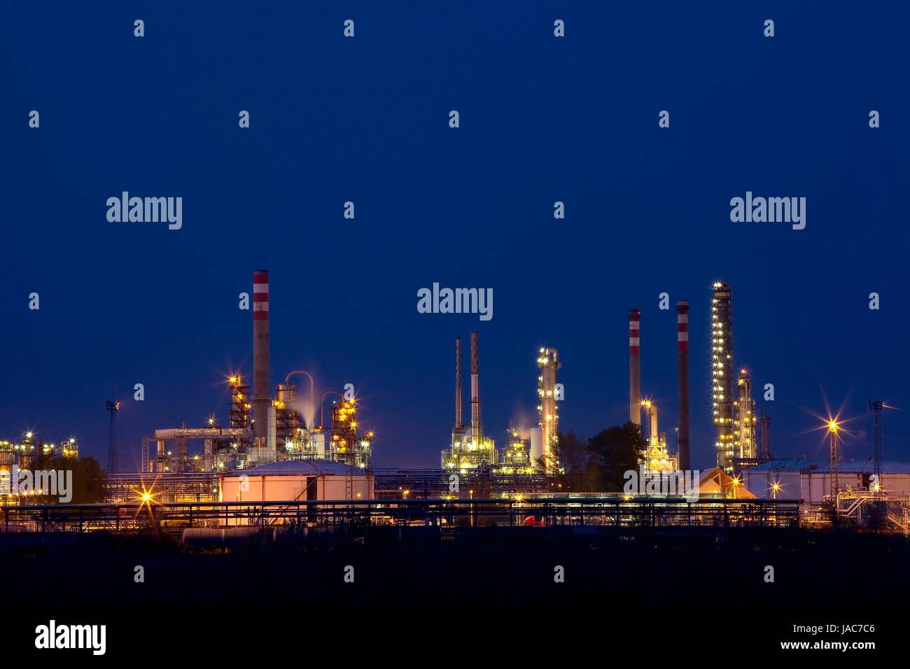 Oil refinery buildings at night Stock Photo - Alamy