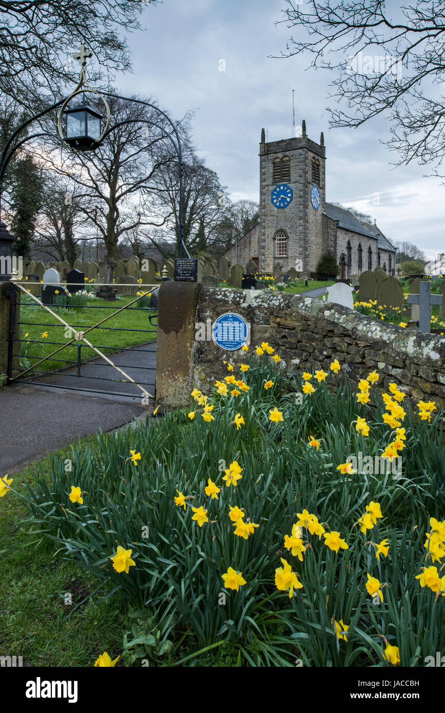 Springtime evening view of gateway entrance, daffodils in churchyard ...