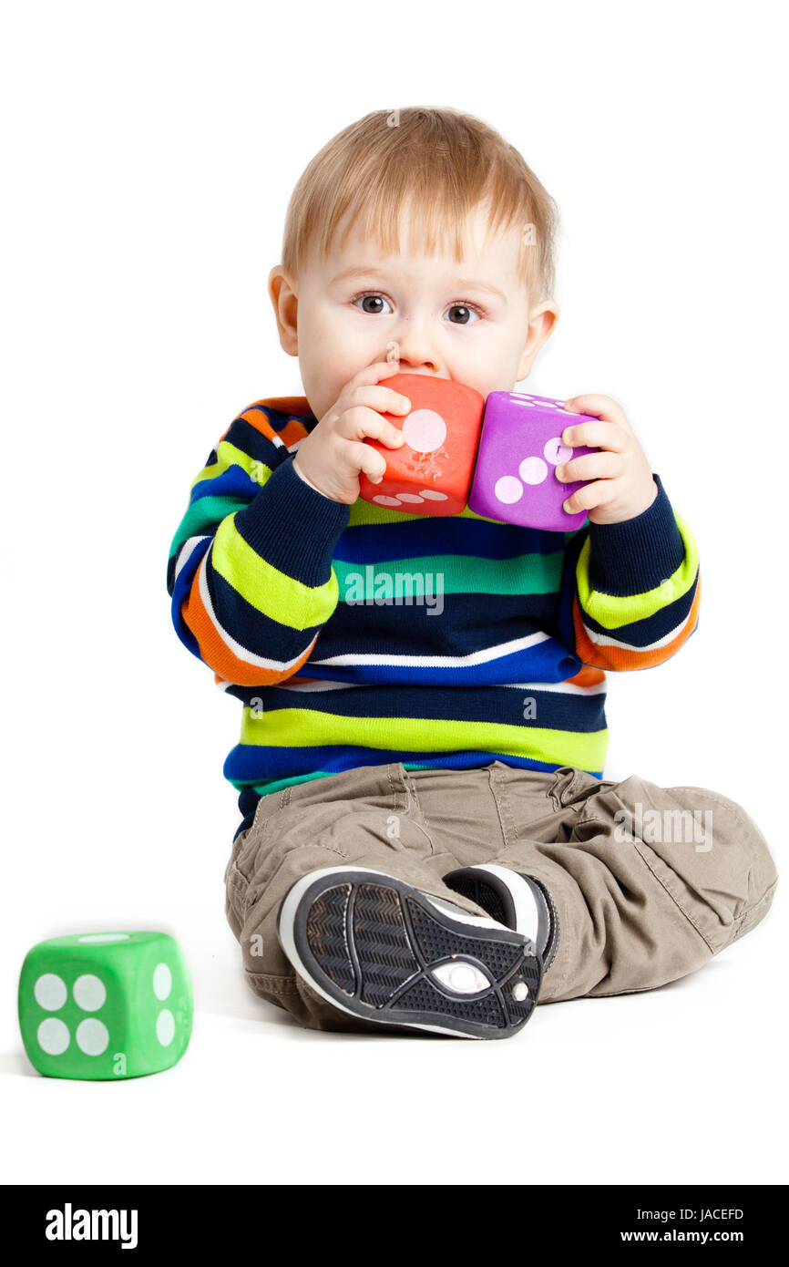 baby is playing with toys over white background. Funny little kid ...