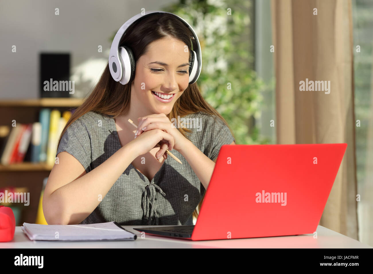 Portrait of a beautiful student viewing and listening video tutorials ...