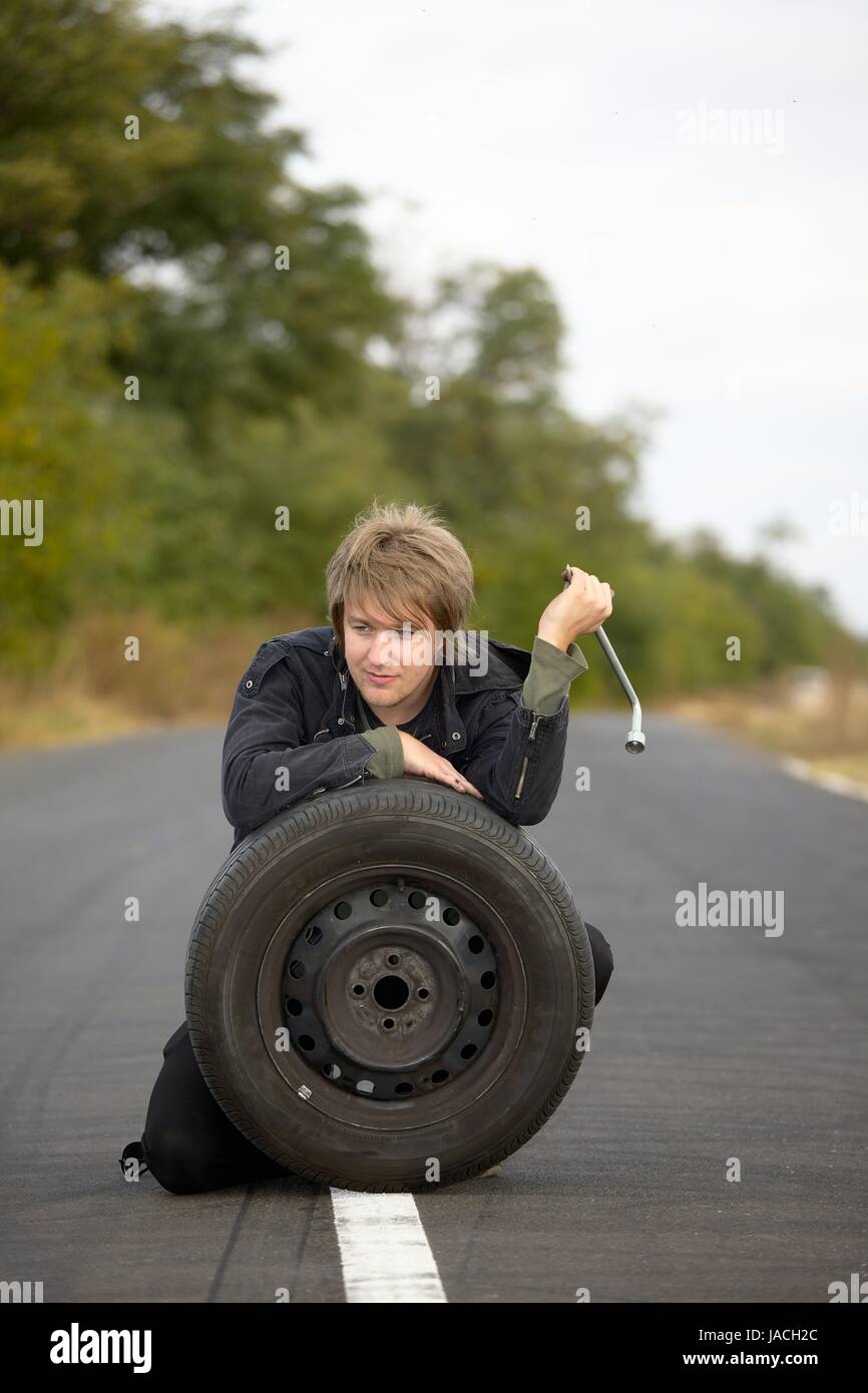 Man with wheel on the road Stock Photo - Alamy