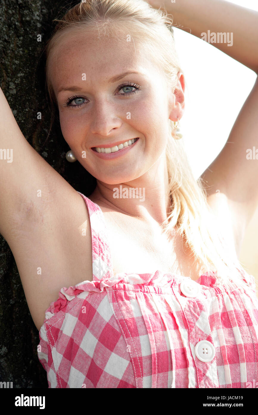 young woman leaning against a tree Stock Photo - Alamy