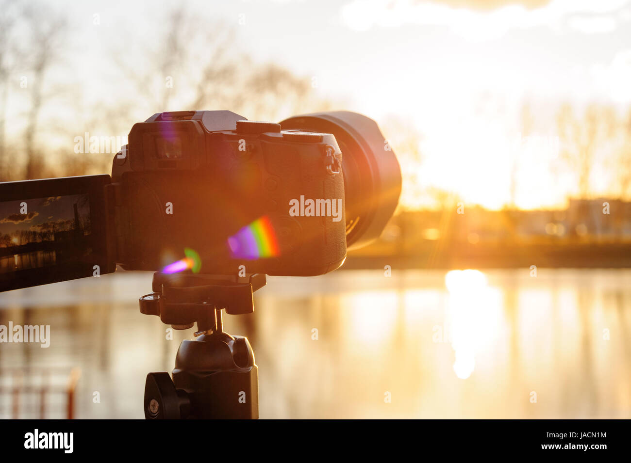 Set the camera on a tripod to record time-lapse video of the sunset ...