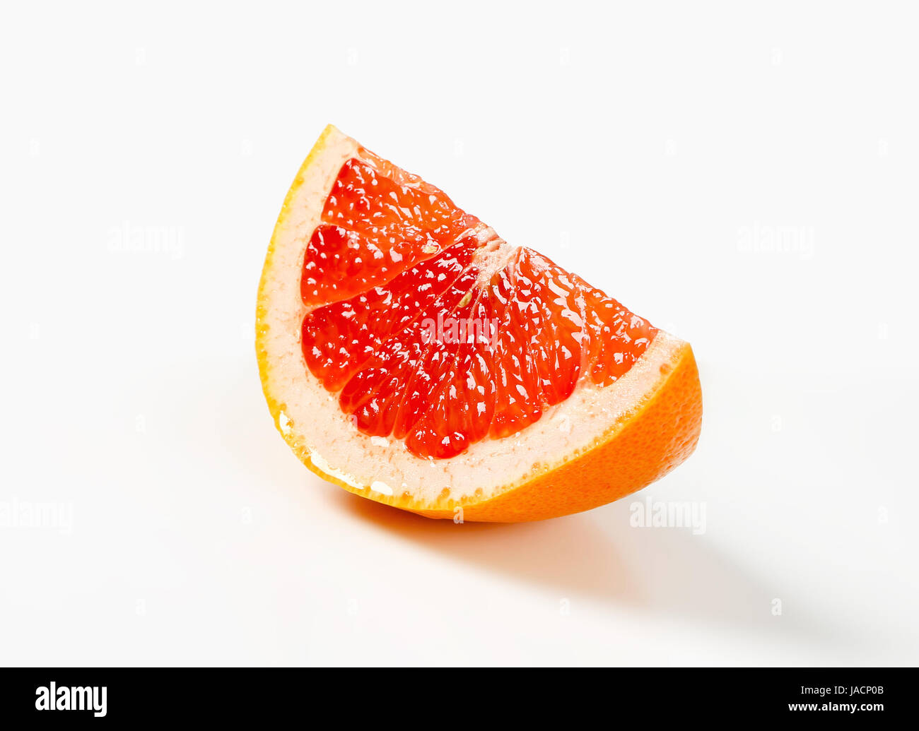 Wedge of fresh red grapefruit Stock Photo - Alamy