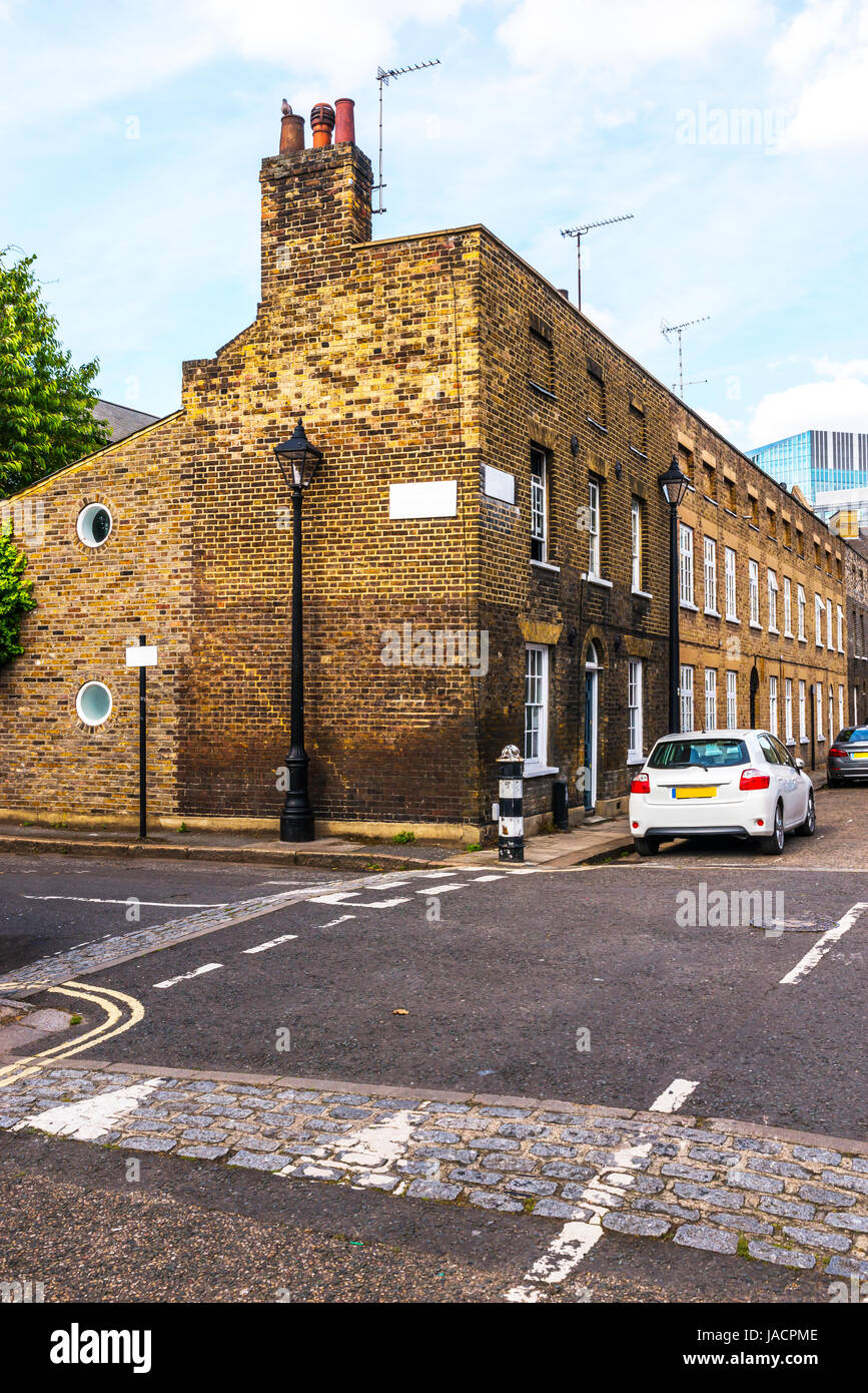 Typical old English buildings, low brick buildings across a narrow ...