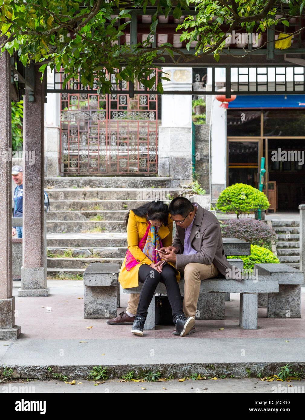 Yangshuo, China. Couple Checking their Cell Phone Stock Photo - Alamy