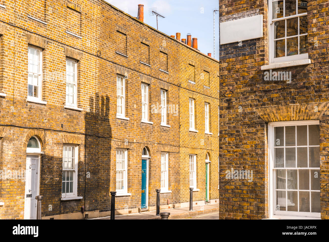 Typical old English buildings, low brick buildings across a narrow ...