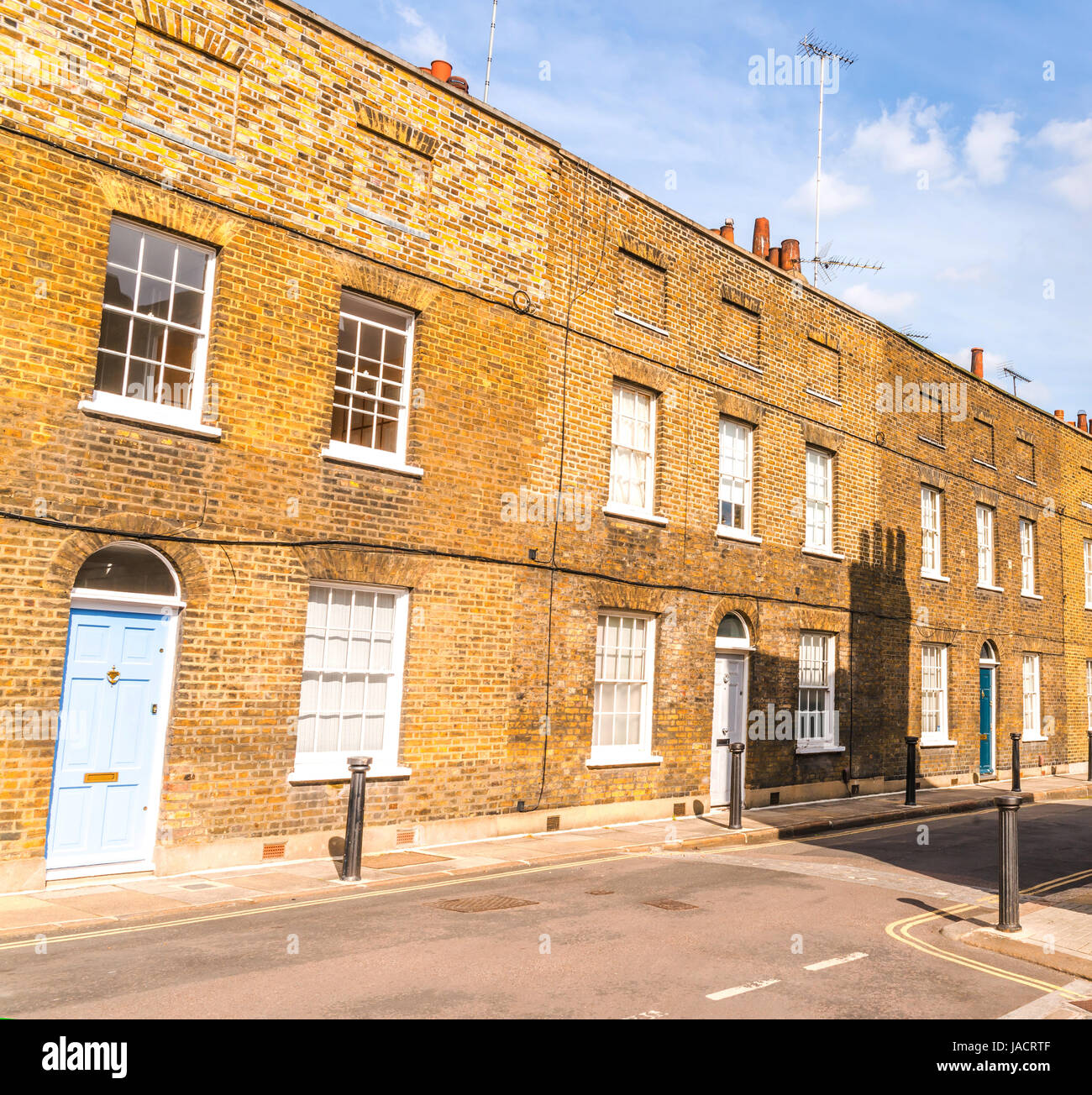 Typical old English buildings, low brick buildings across a narrow ...