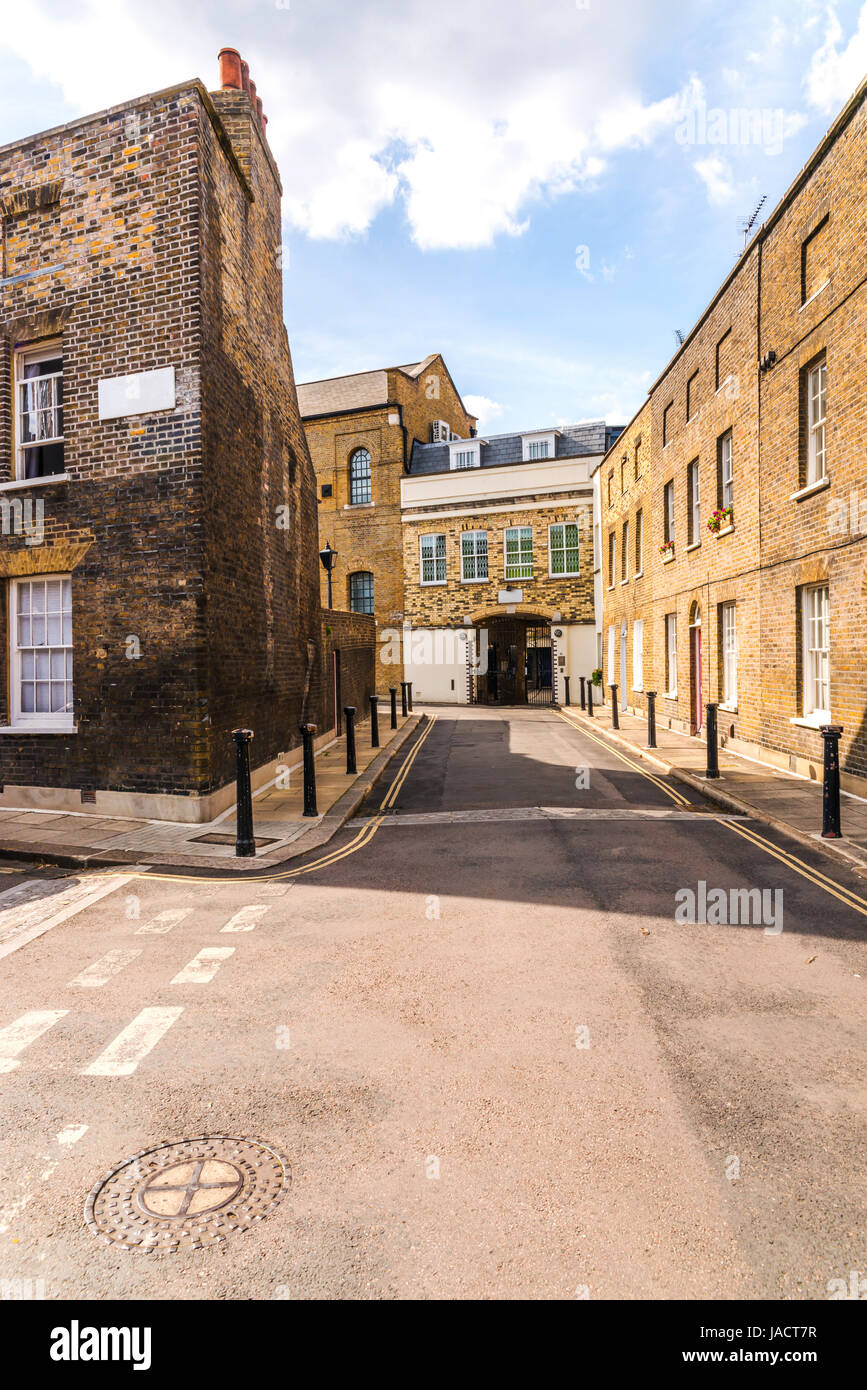 Typical old English buildings, low brick buildings across a narrow ...