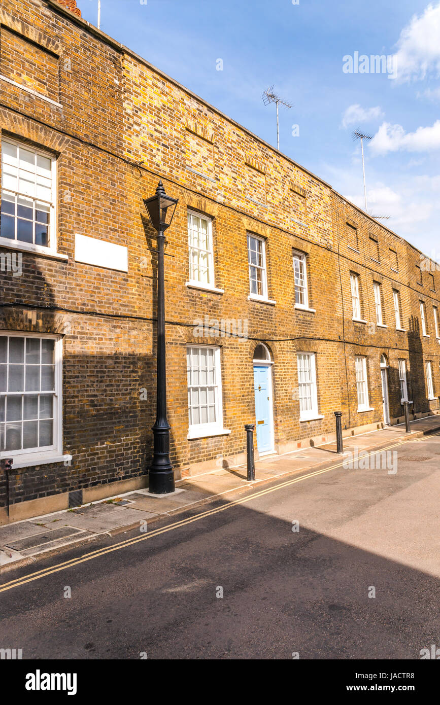 Typical old English buildings, low brick buildings across a narrow ...