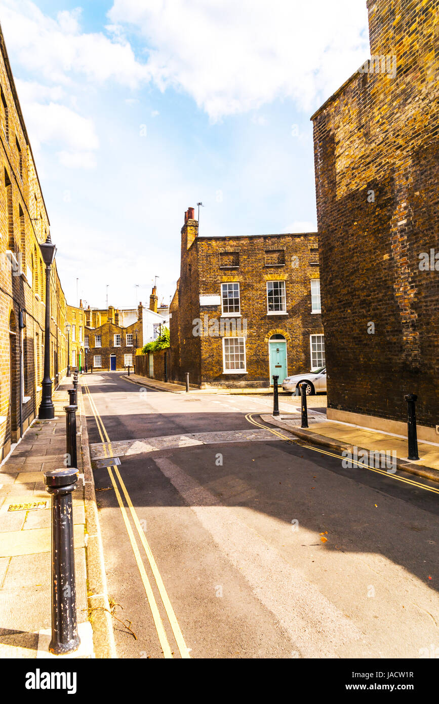 Typical old English buildings, low brick buildings across a narrow ...