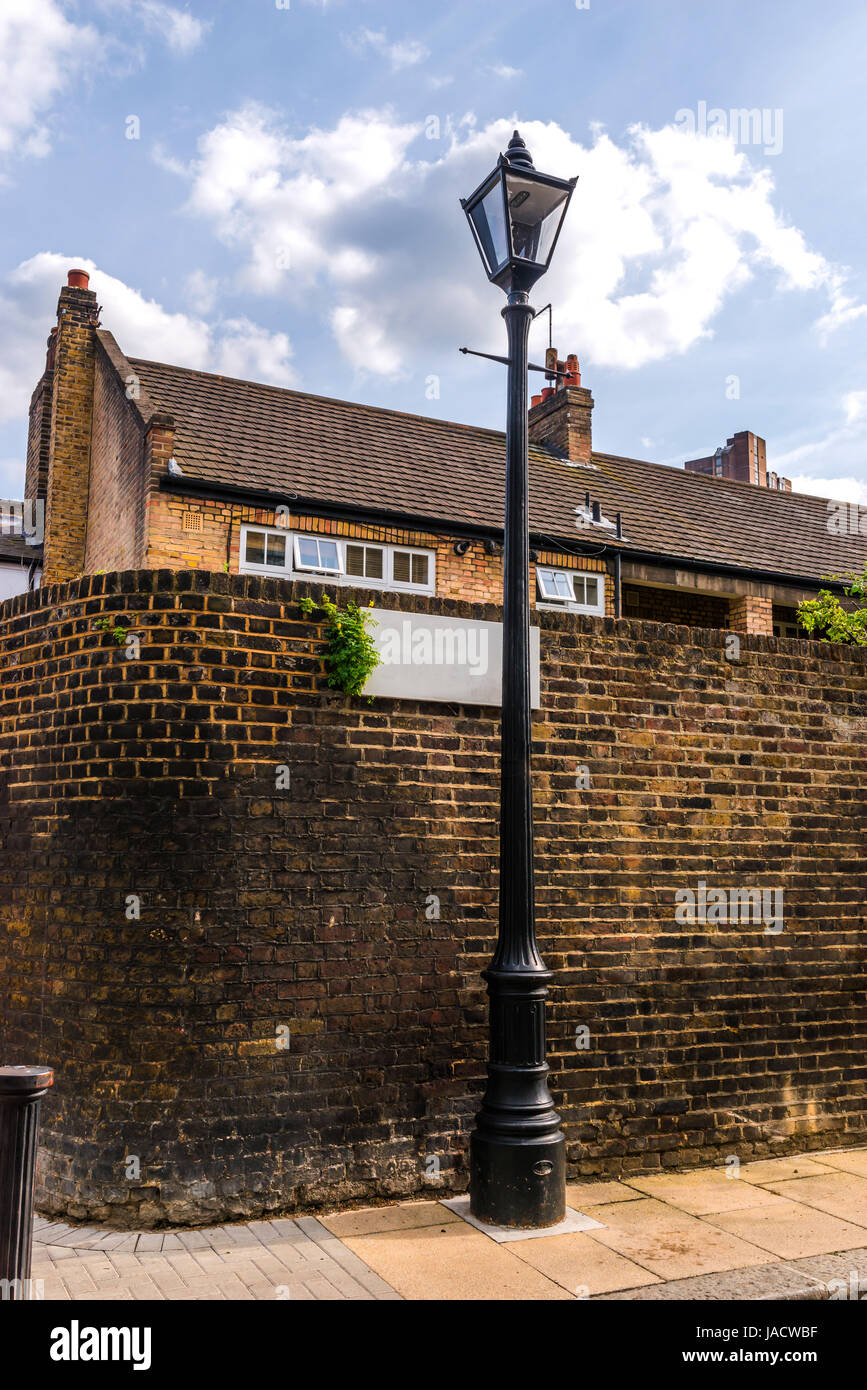 Typical old English buildings, low brick buildings across a narrow ...