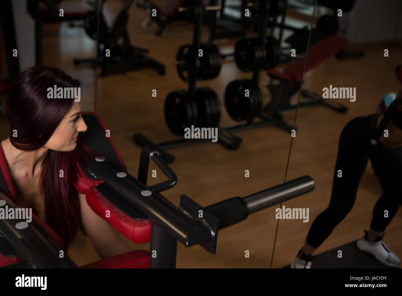 Woman Working Out Legs On Machine In A Gym - Leg Exercise Stock Photo ...