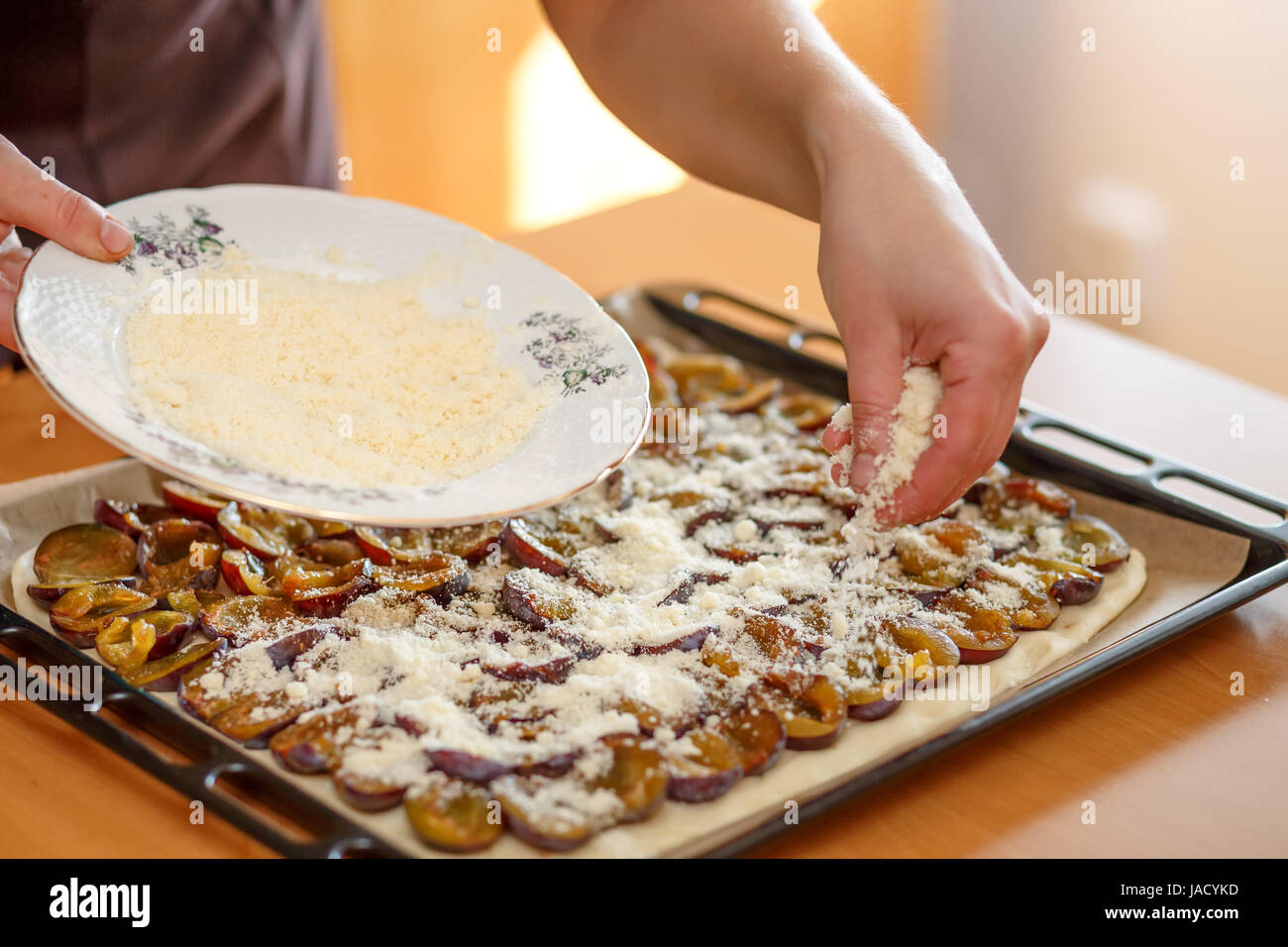 preparing, baking plum cake, adding crumb to plums on dough Stock Photo ...