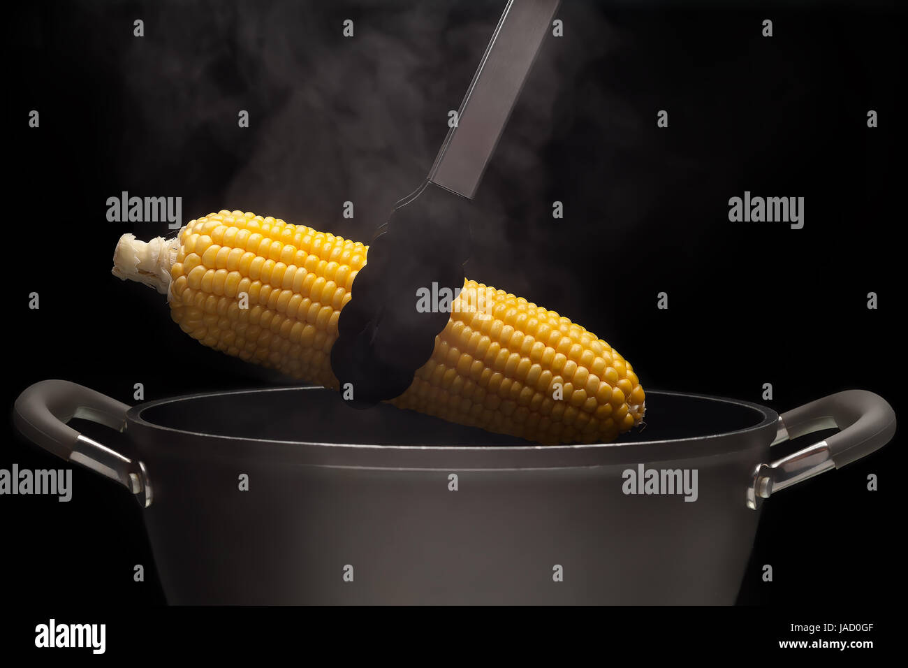 Hot corn from pot with steam on black background Stock Photo - Alamy