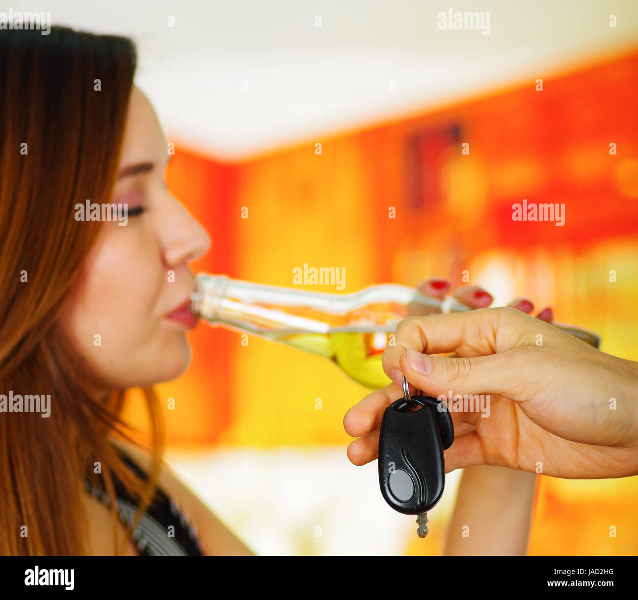 Portrait of a drunk woman drinking a beer with a blurred hand holding a ...