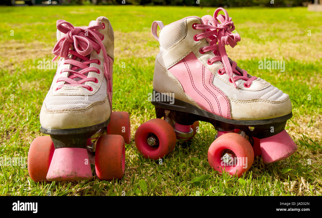 Beautiful pink roller skates on grass background Stock Photo - Alamy