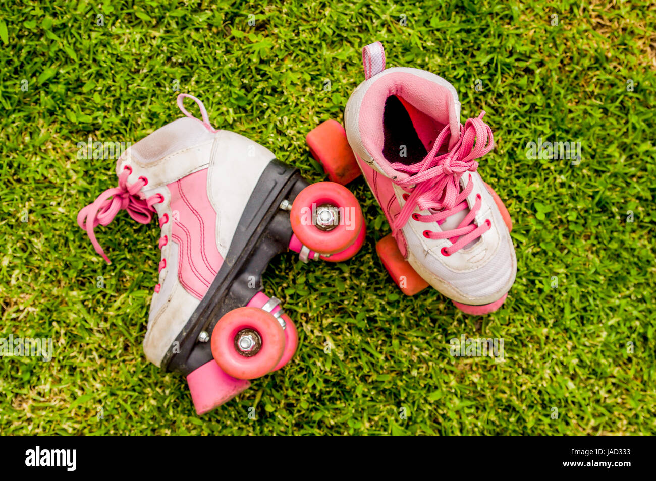 Beautiful pink roller skates on grass background Stock Photo - Alamy