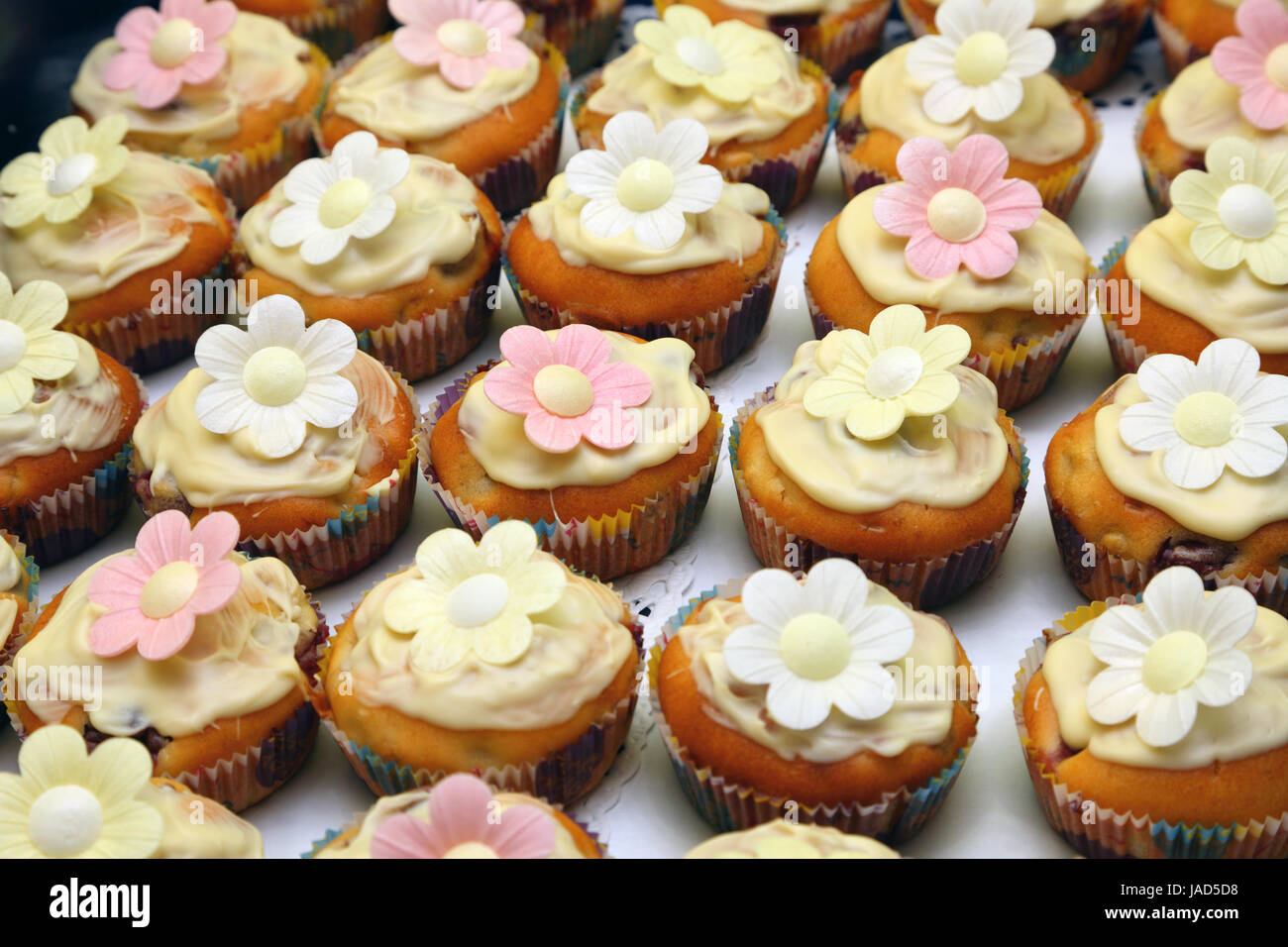 Muffins decorated with colorful flowers Stock Photo - Alamy