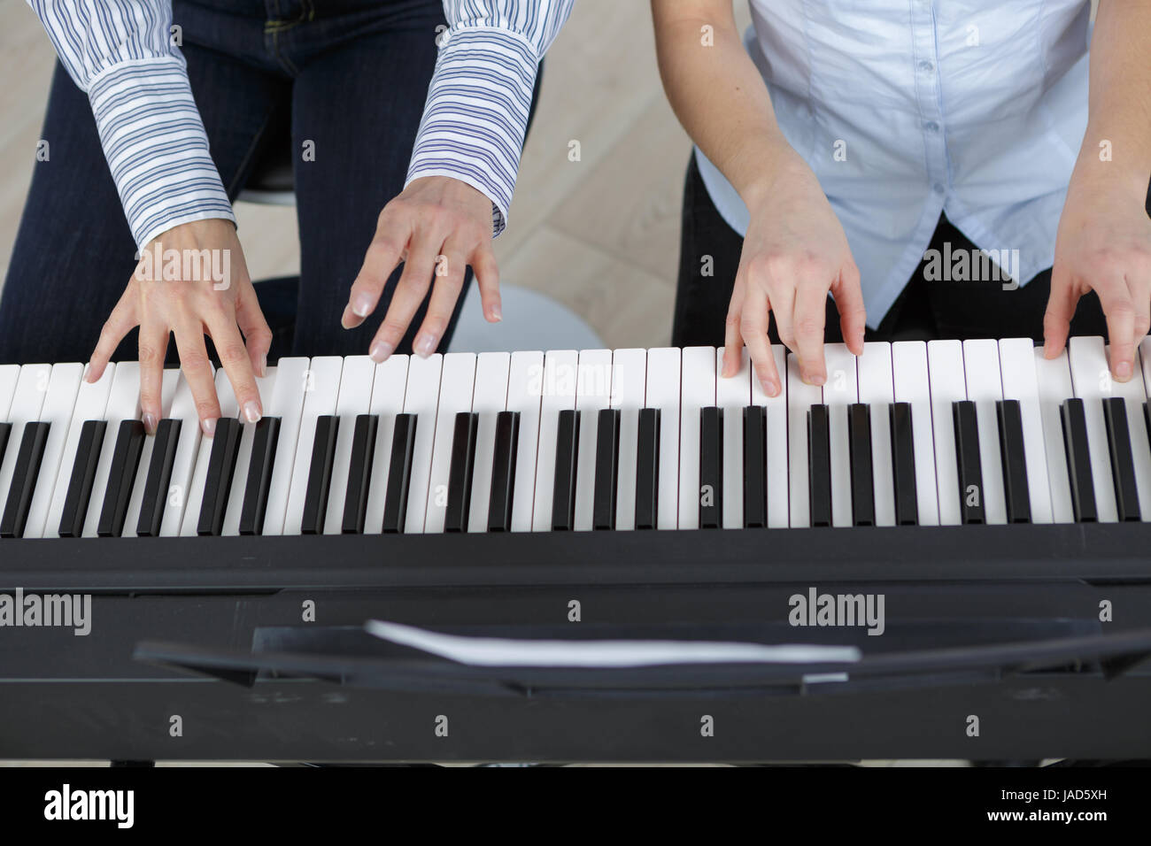 piano keyboard top view and hands of two players Stock Photo - Alamy
