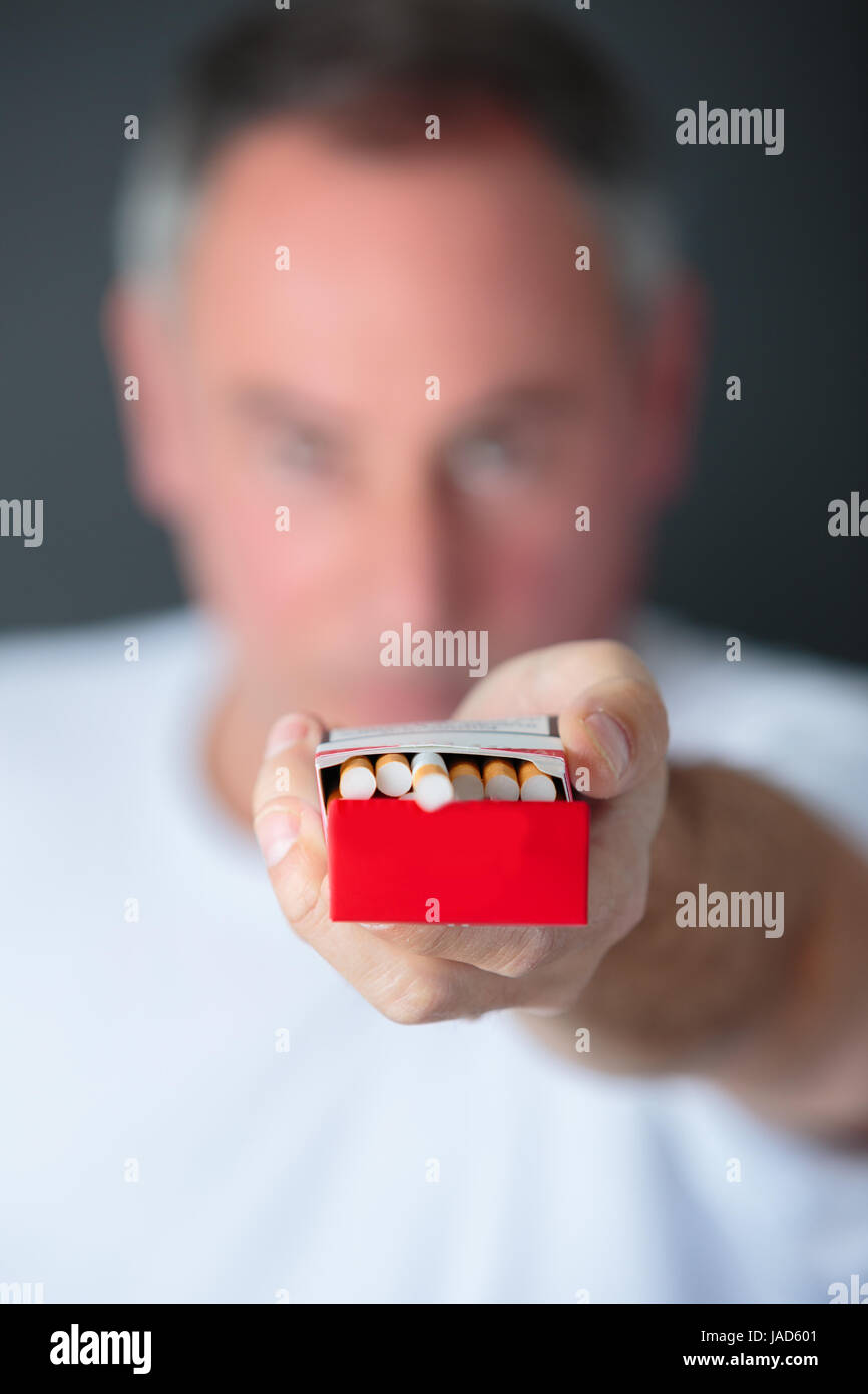 man is offering cigarette from cigarette pack Stock Photo - Alamy