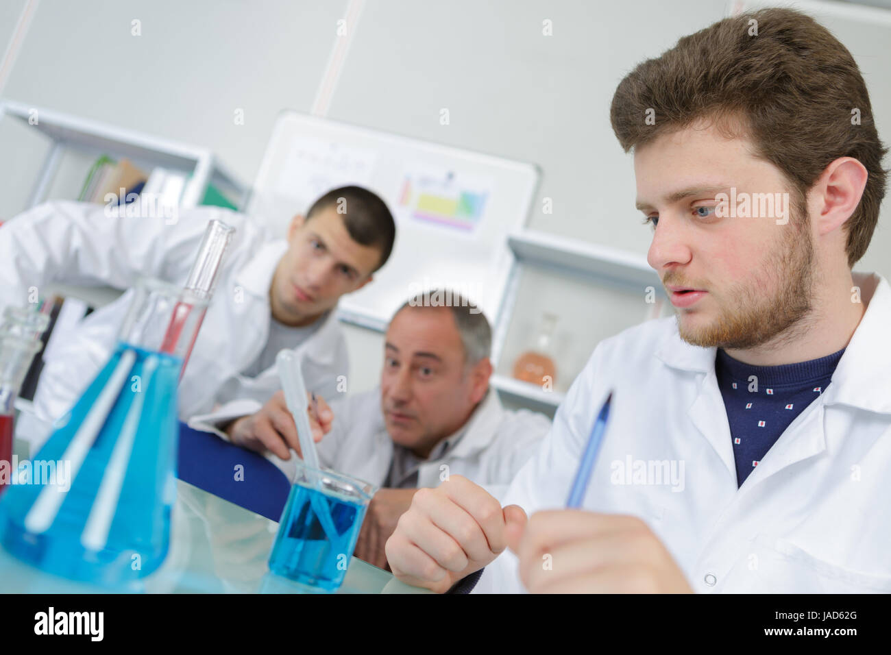 supervisor helping trainee with pippetes Stock Photo - Alamy