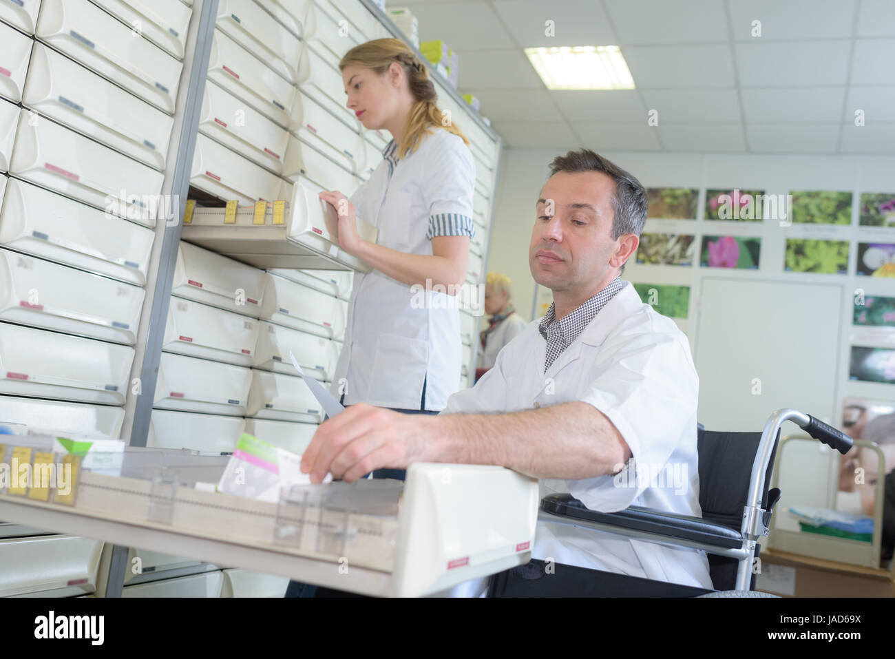 pharmaceutical chemist opening drawer for drugs storage in farmacy ...