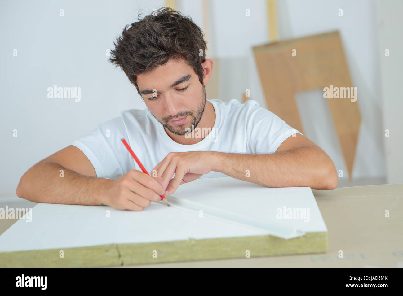 worker drawing a mark on laminate using ruler Stock Photo - Alamy