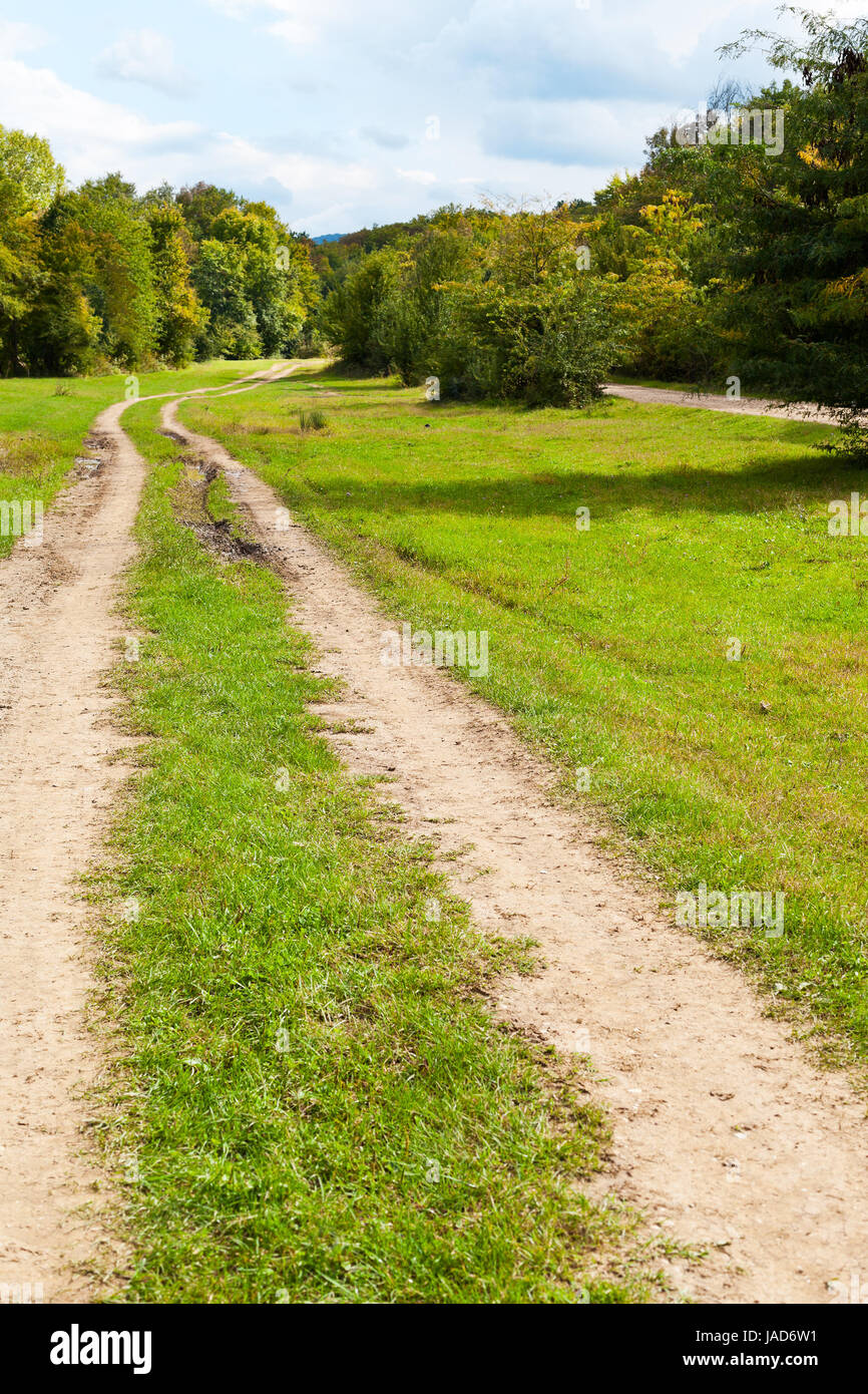 two-track dirt country road in caucasus mountains in early autumn day ...