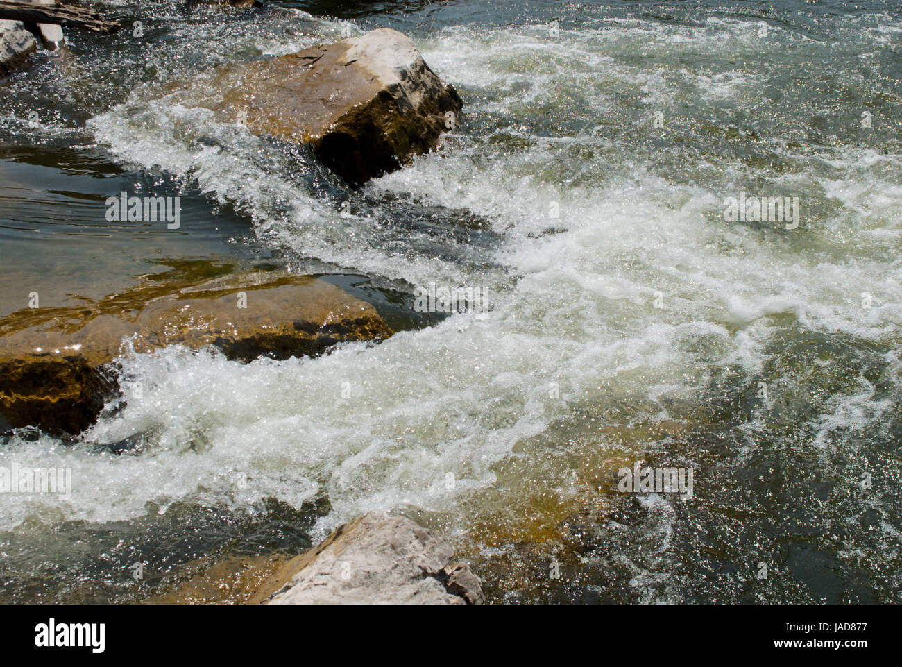 Brown rocks and churning water in clear river Stock Photo - Alamy