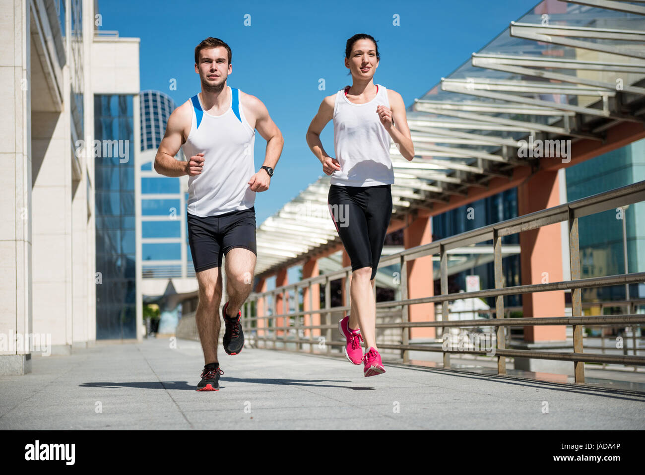Young sport couple jogging together in city environment Stock Photo - Alamy